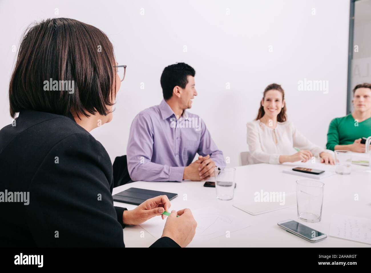 Group of office workers at a meeting around the boss Stock Photo - Alamy
