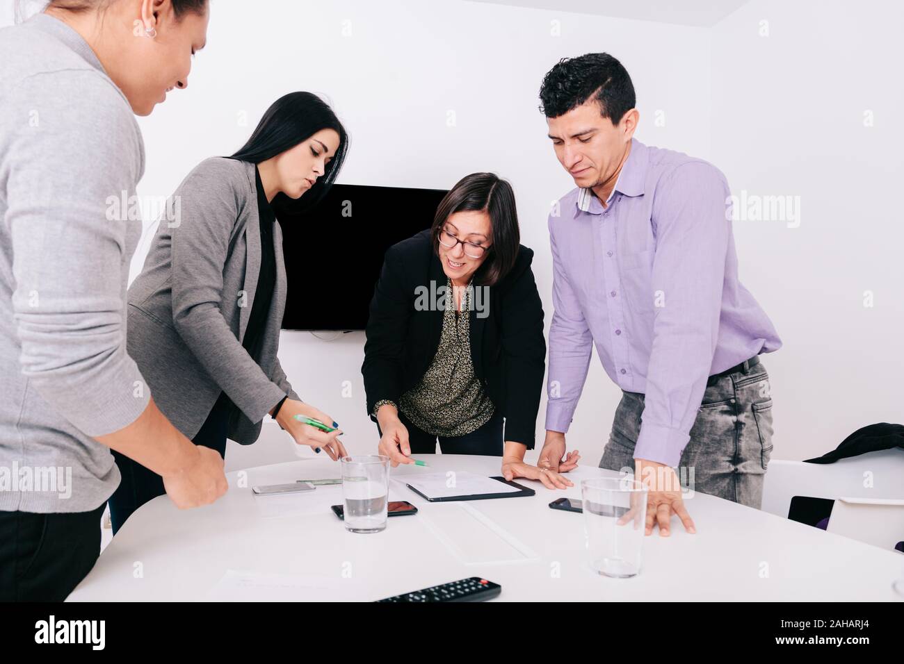 Group of office workers at a meeting around the boss Stock Photo - Alamy