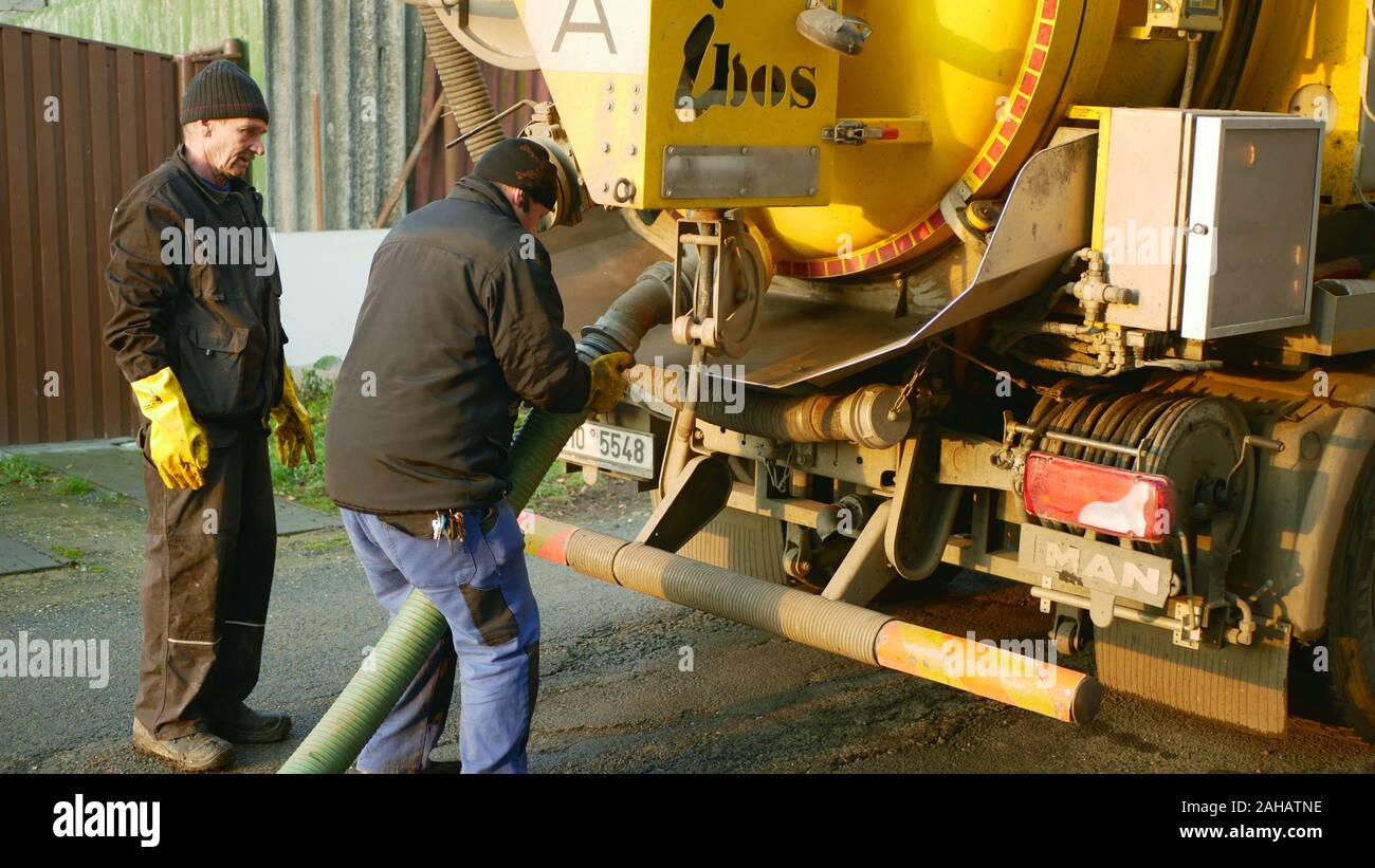 Septic cesspool pumping into tank truck by suction hose under high ...