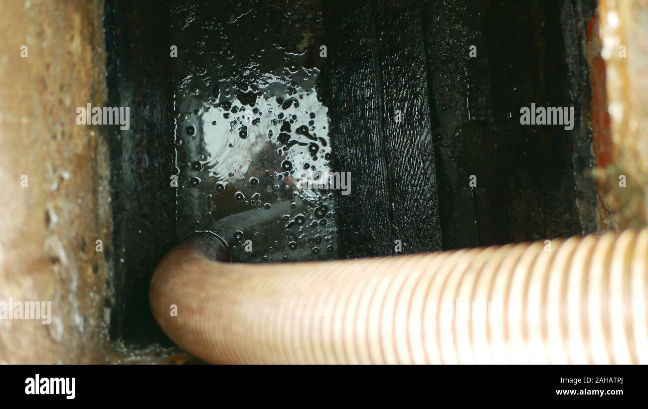 Septic cesspool pumping into tank by suction hose under high pressure ...