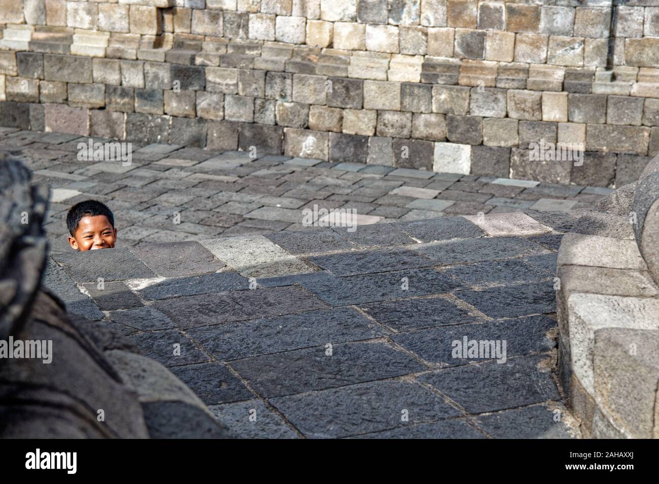 Happy indonesian 6-8 years old boy, plays in peekaboo in Borobodur ...