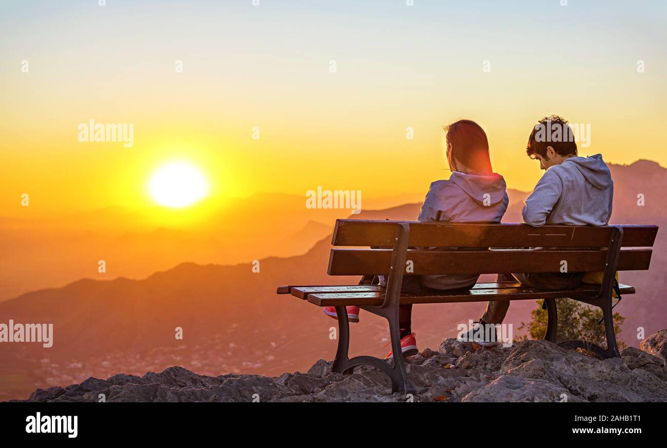 Couple sitting on bench at sunset hi-res stock photography and images ...