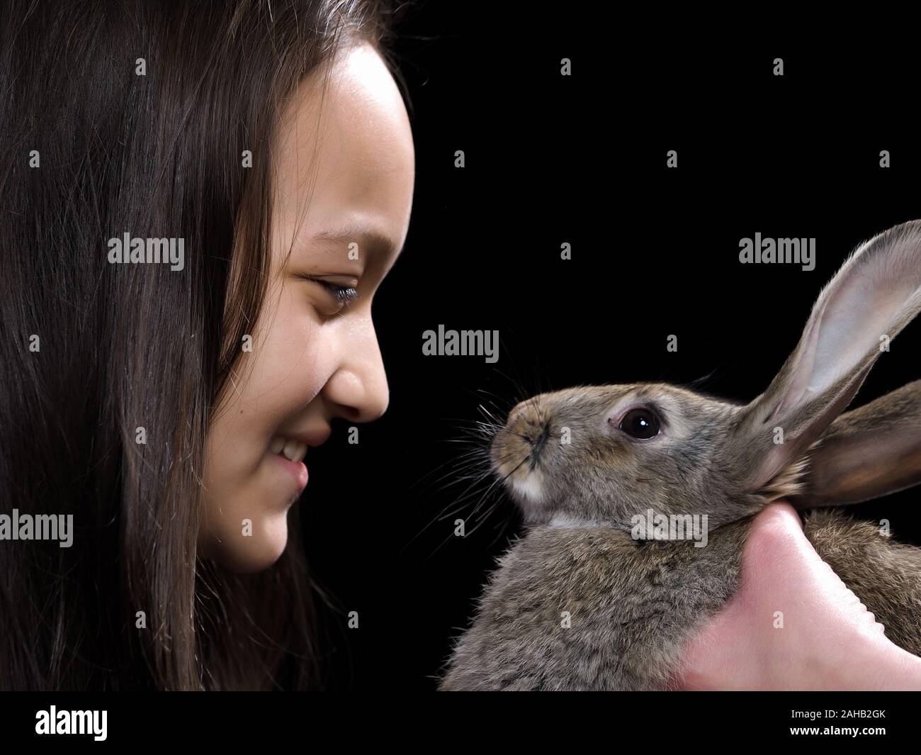 A girl's face and a rabbit's face. Black background Stock Photo - Alamy