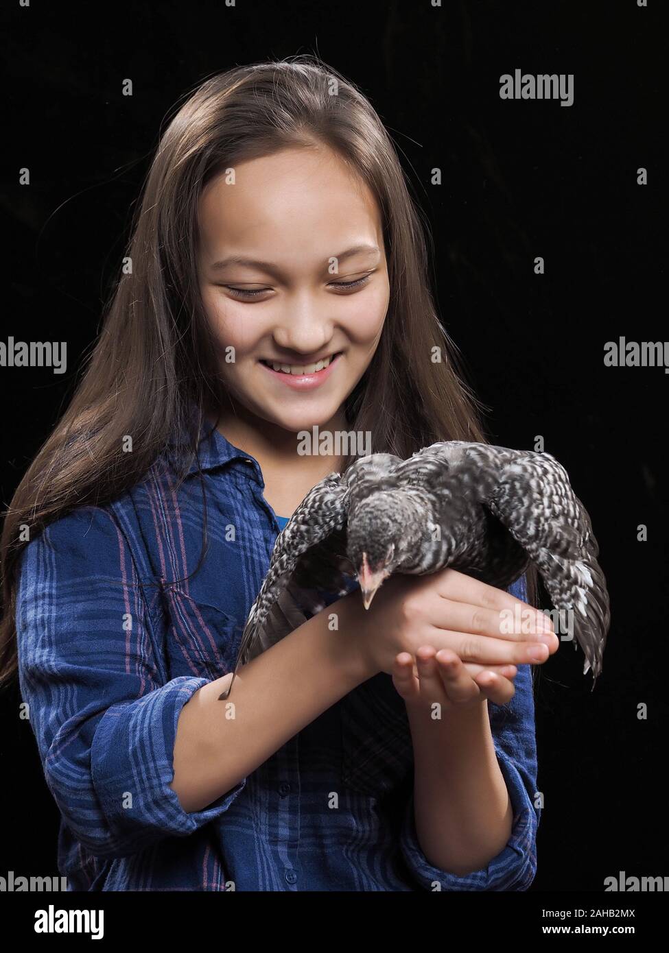 Portrait of a girl with a bird. Black background Stock Photo - Alamy