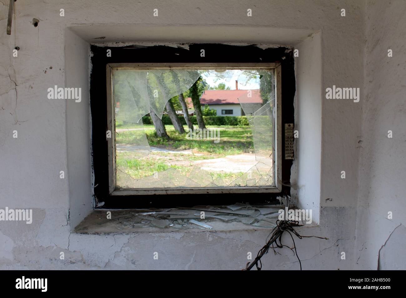 Broken small window with metal frame and shattered glass overlooking ...