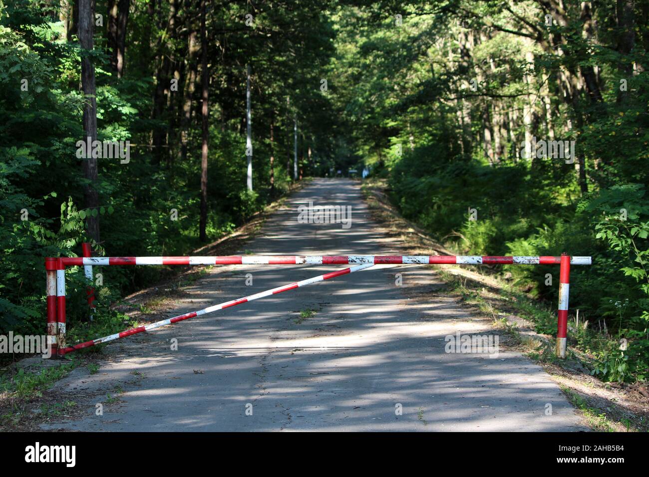 Closed and locked rusted metal red and white striped ramp blocking ...