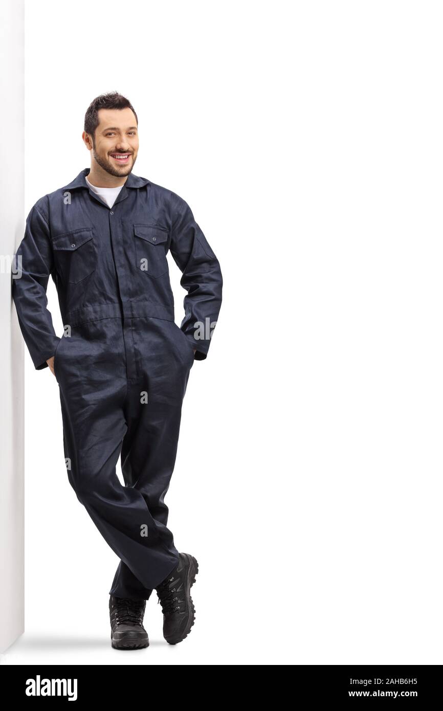 Full length portrait of a male worker in an overall uniform leaning on ...