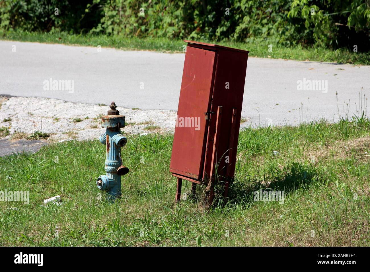 Leaning dark red metal fire department box locked with padlock next to ...