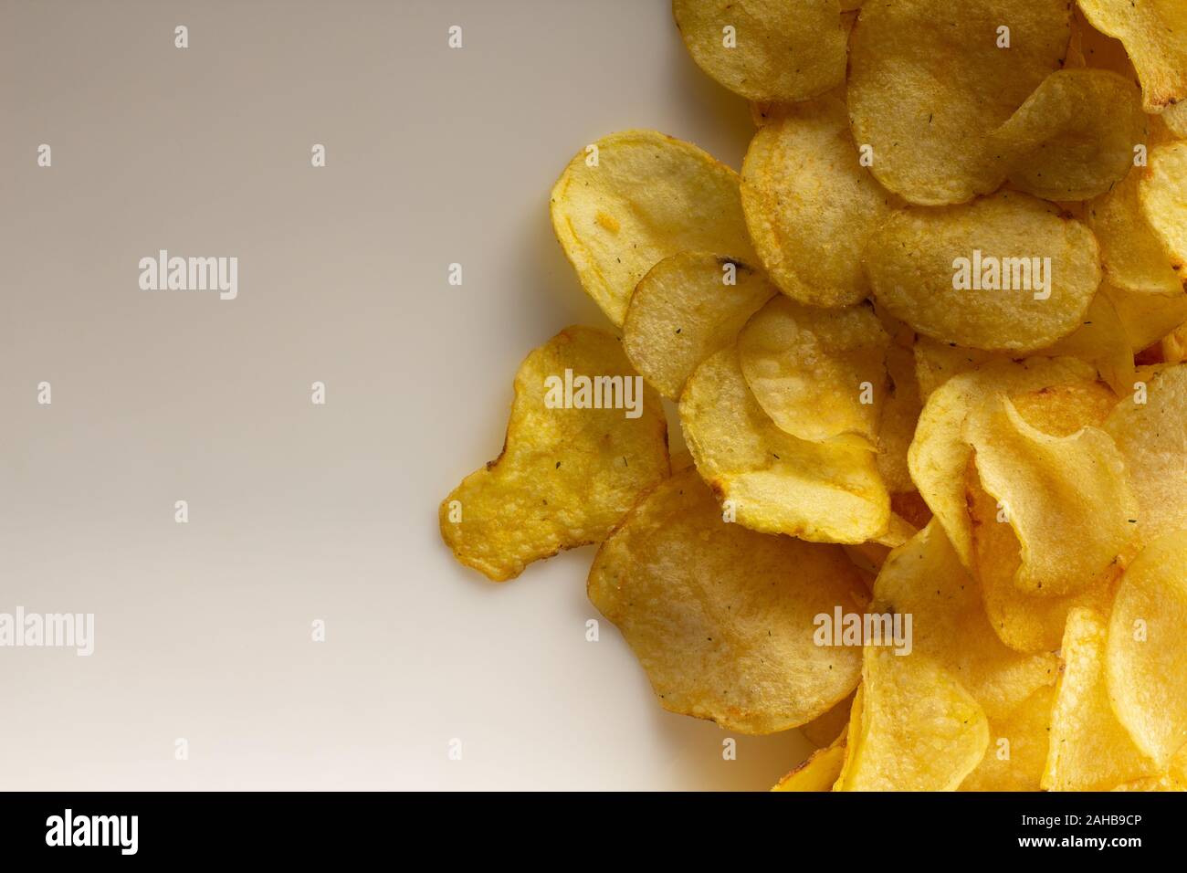 golden brown potato chips on a white background Stock Photo - Alamy