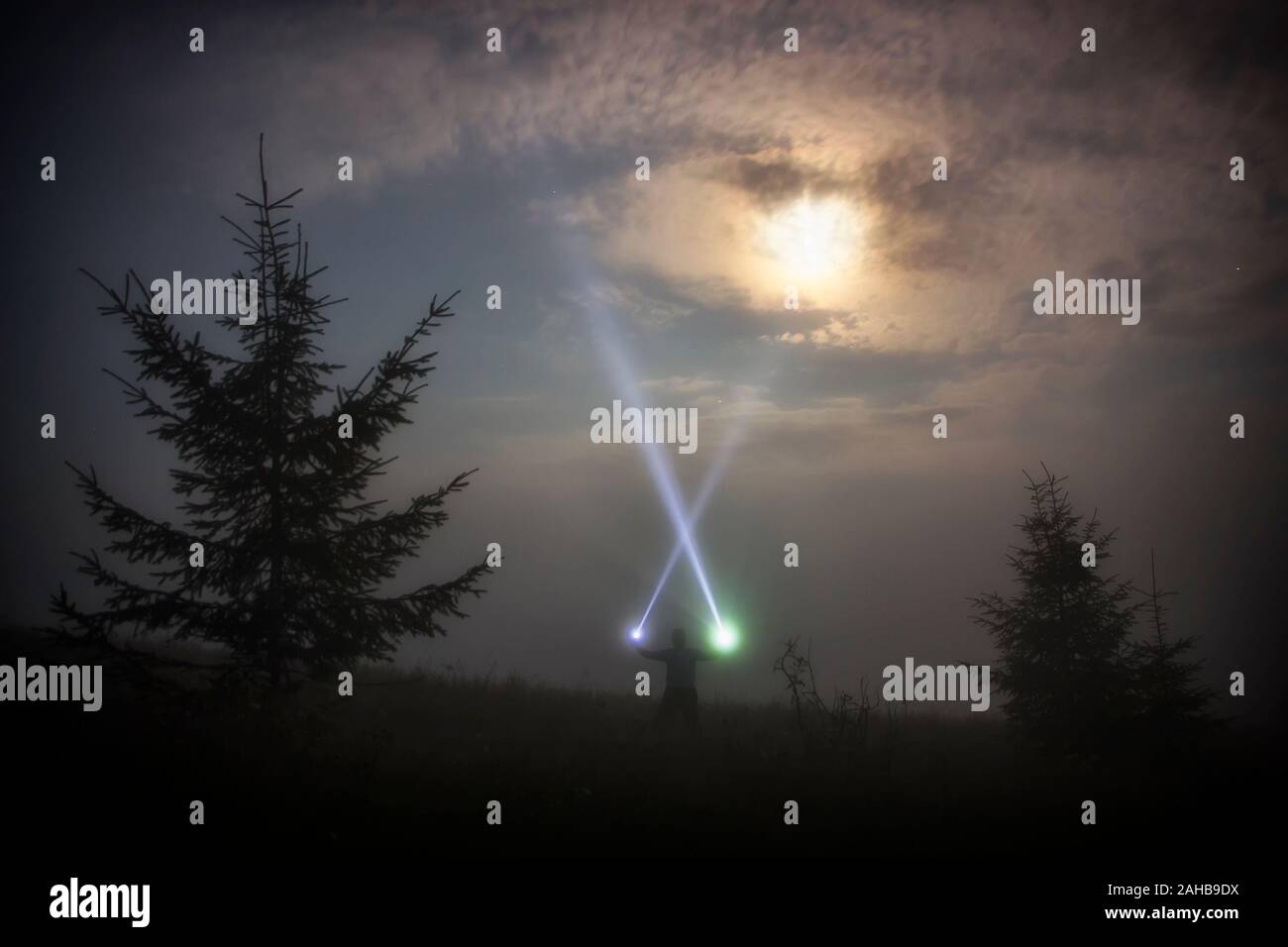Man shines a flashlight in the night moon sky Stock Photo - Alamy