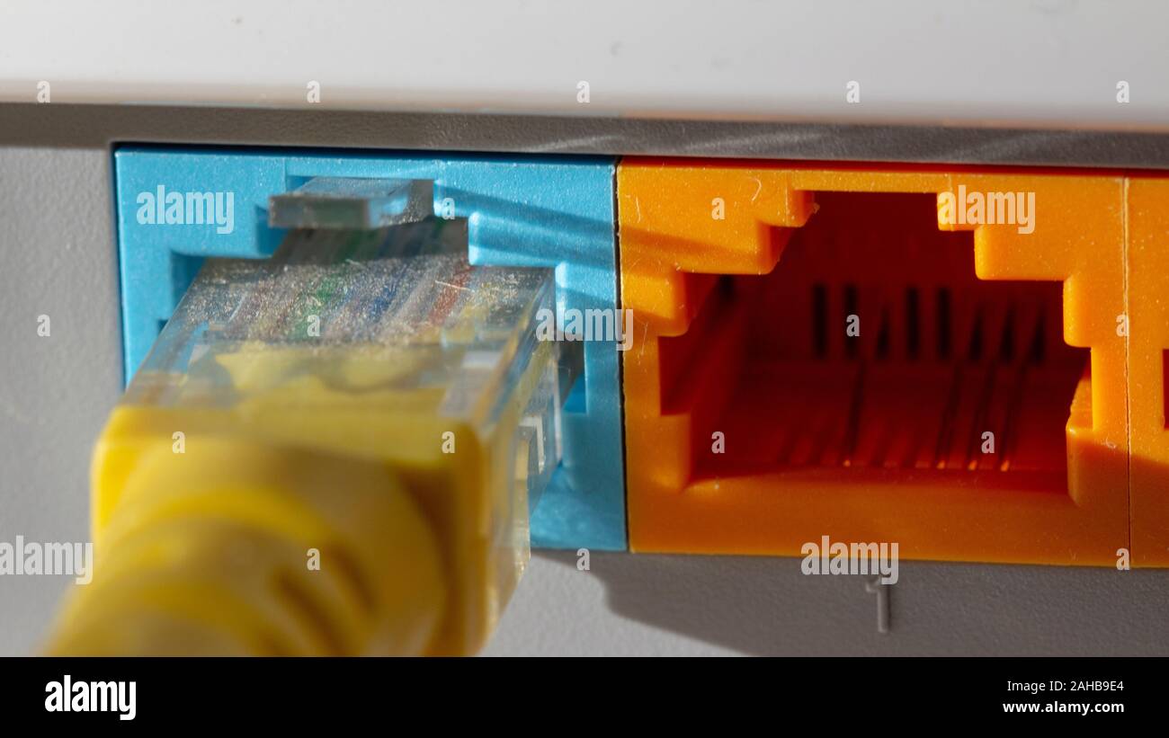 yellow internet cable in blue on the back of the network router Stock ...