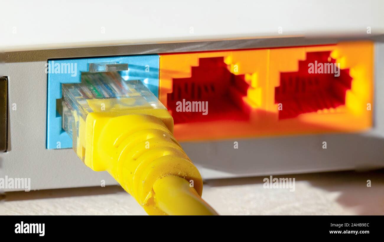 yellow internet cable in blue on the back of the network router Stock ...