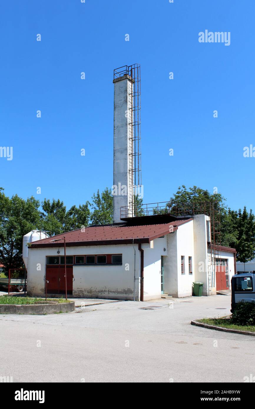 Small industrial building in front of tall narrow white rectangle ...