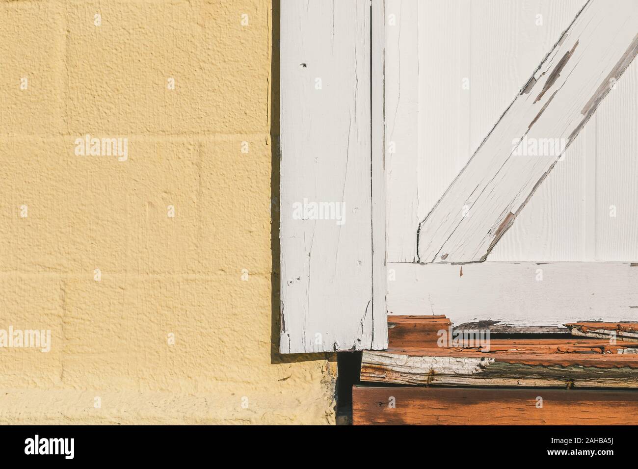 Distressed white barn style door yellow concrete background texture ...