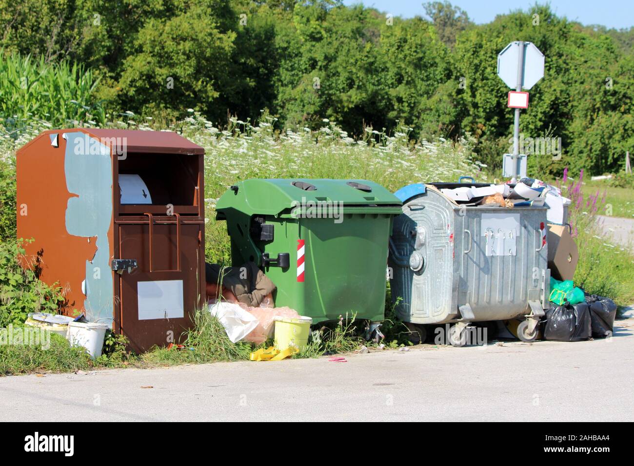 Three various large metal and plastic trash containers for ecologically ...