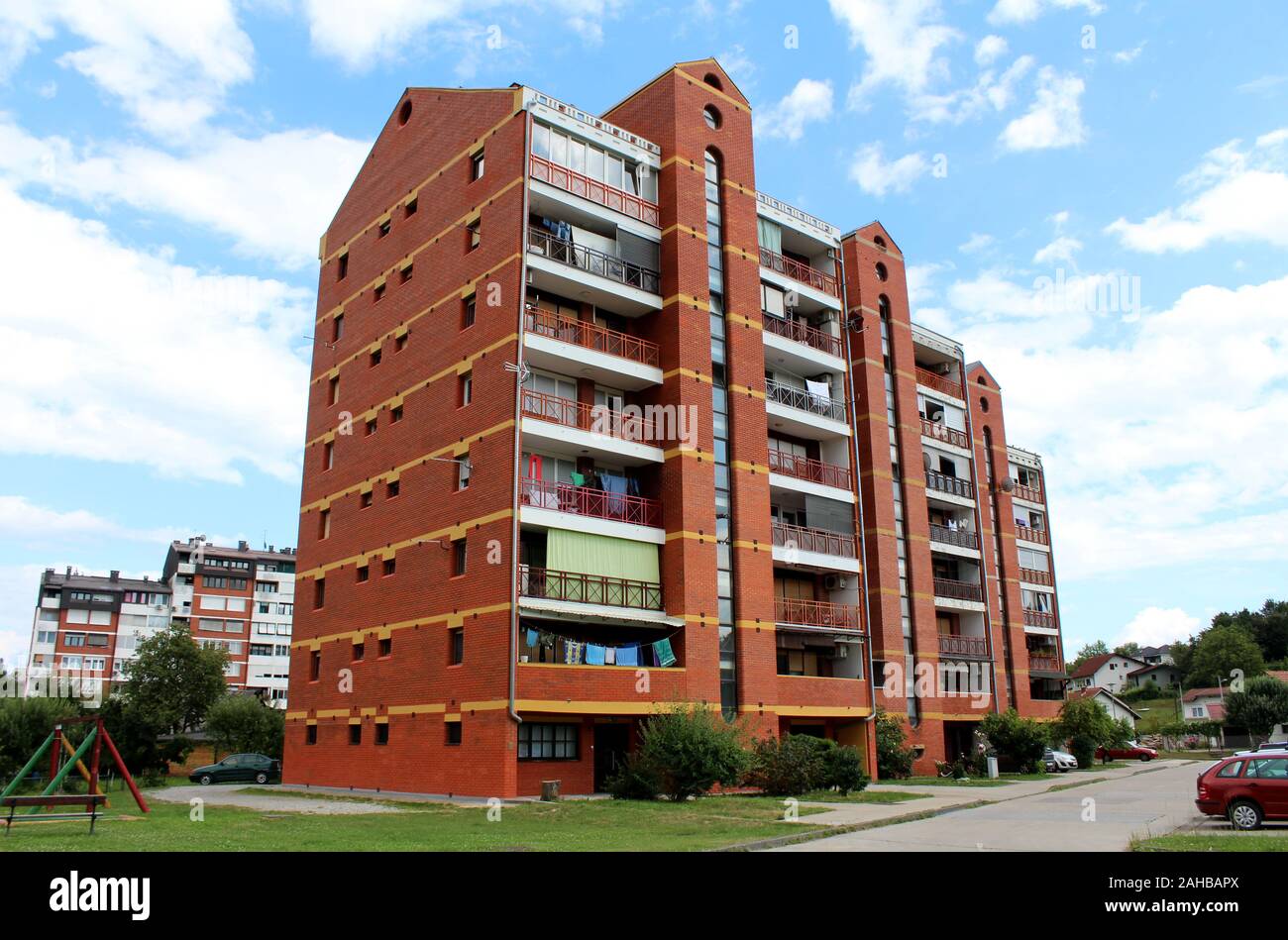 Vintage large red brick apartment building with long balconies with red ...