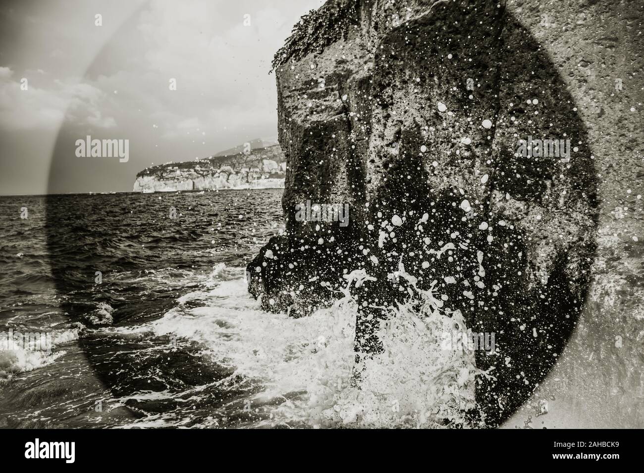 Wave splash on rock cliff in Sorrento, Italy. Blackand white seascape ...