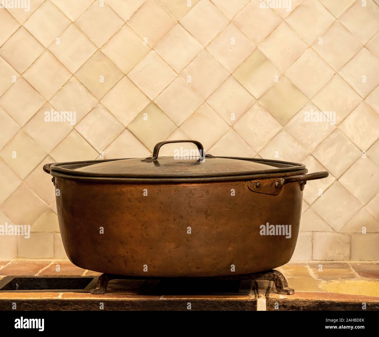 Side view of an old copper cooking pan or casserole pot on kitchen ...