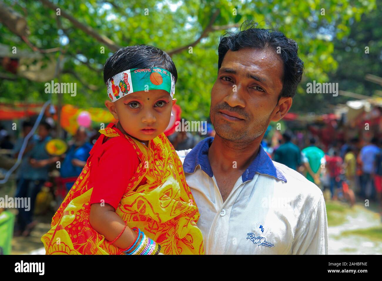 A father and daughter roam inside a Boishakhi Mela, a traditional fair ...