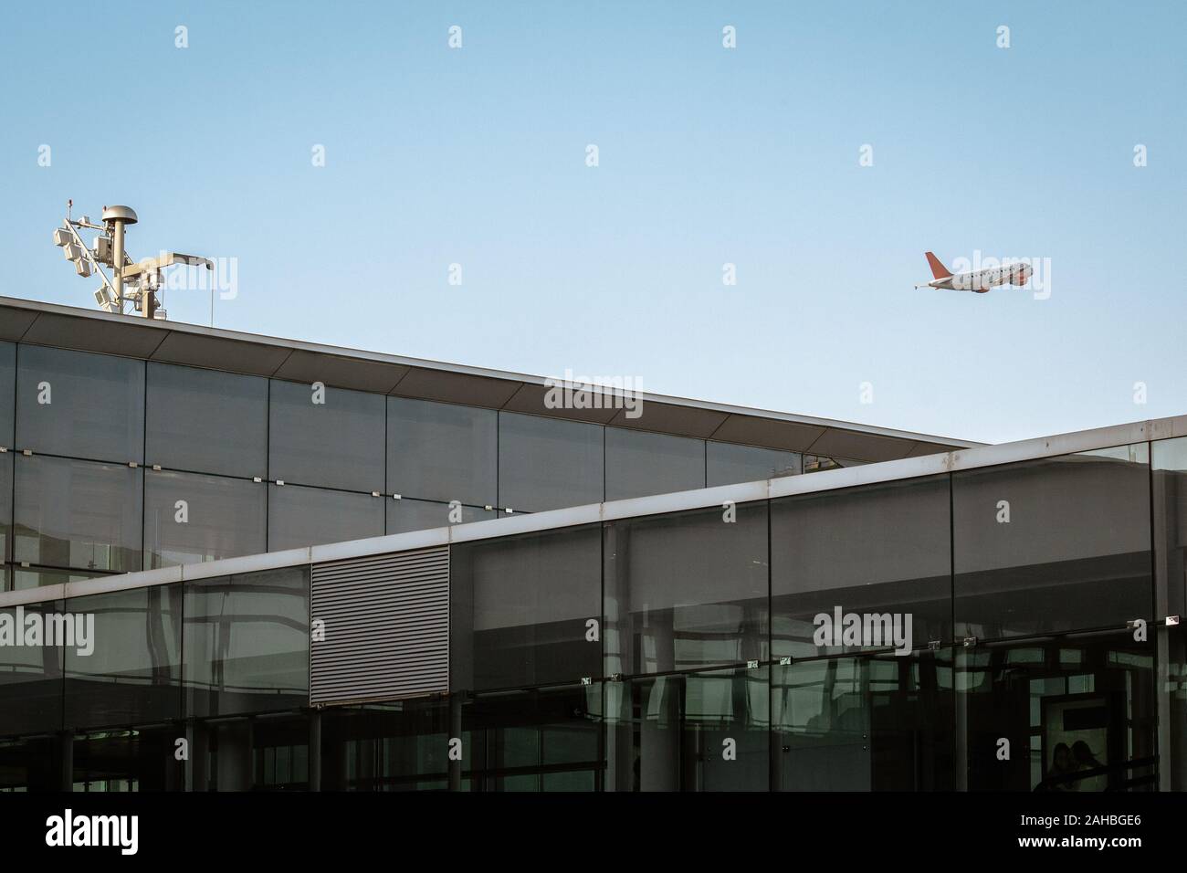 Airplane taking off in the distance. Terminal building and radio tower ...