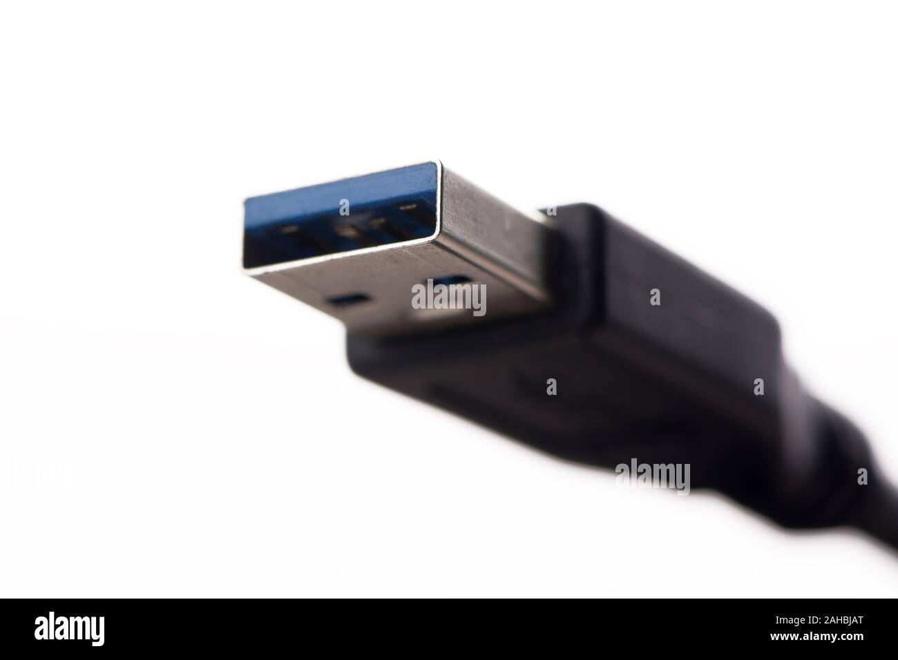 USB cable connector with blurred cable close up on white background ...