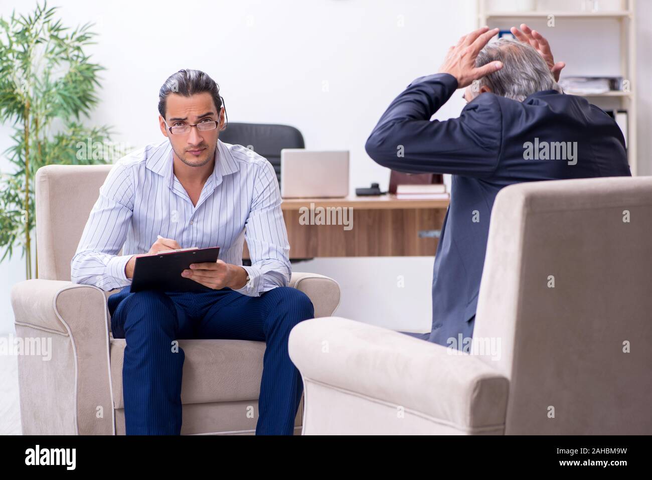 The old man visiting young male doctor psychologist Stock Photo - Alamy