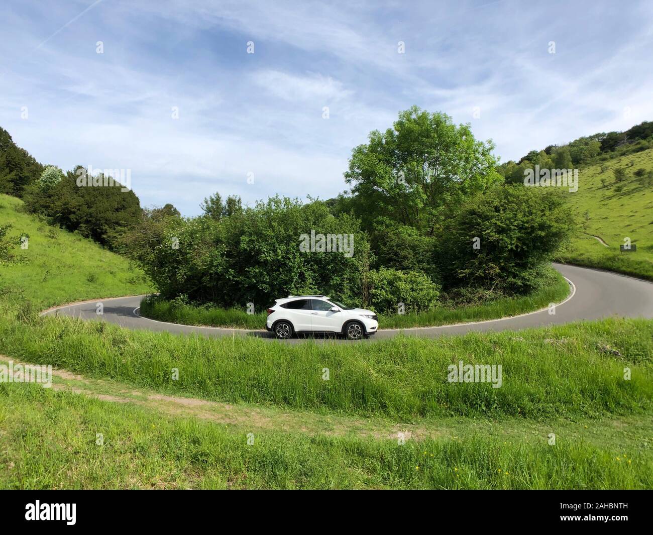 SUV driving around a bend in the road Stock Photo - Alamy