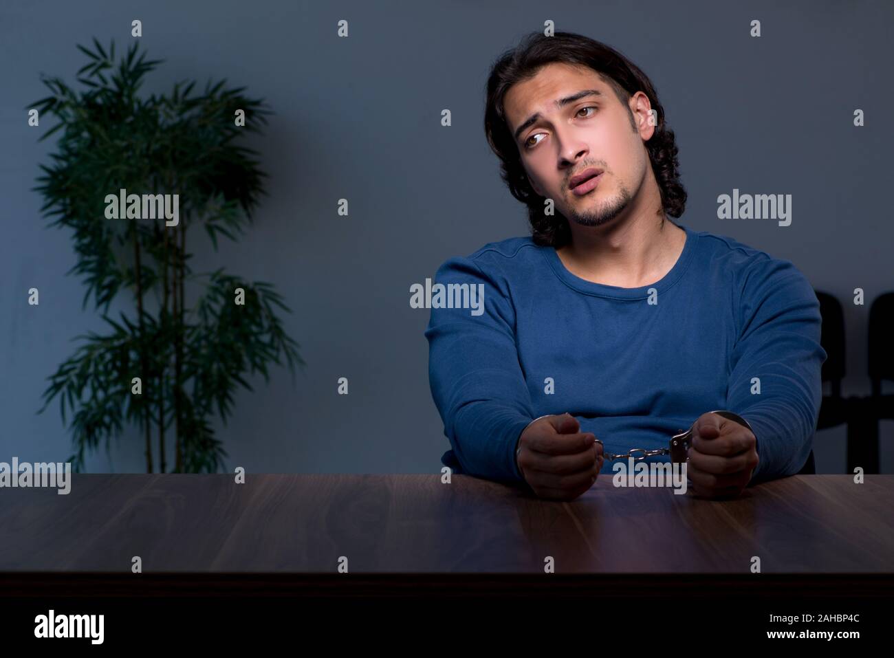 The young convict man sitting in dark room Stock Photo - Alamy