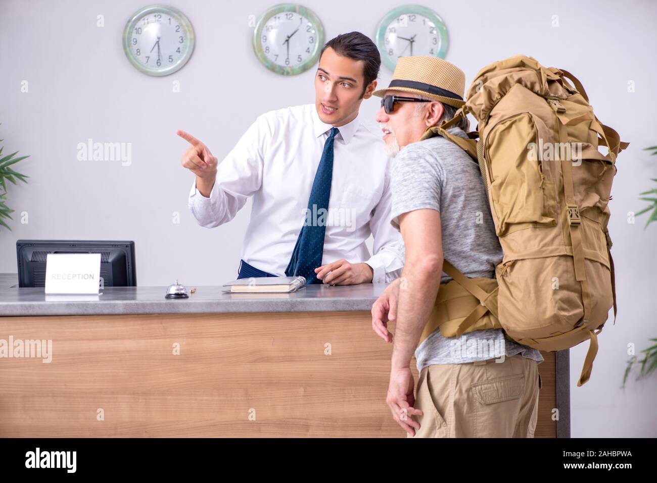 Old backpacker at the hotel reception Stock Photo - Alamy