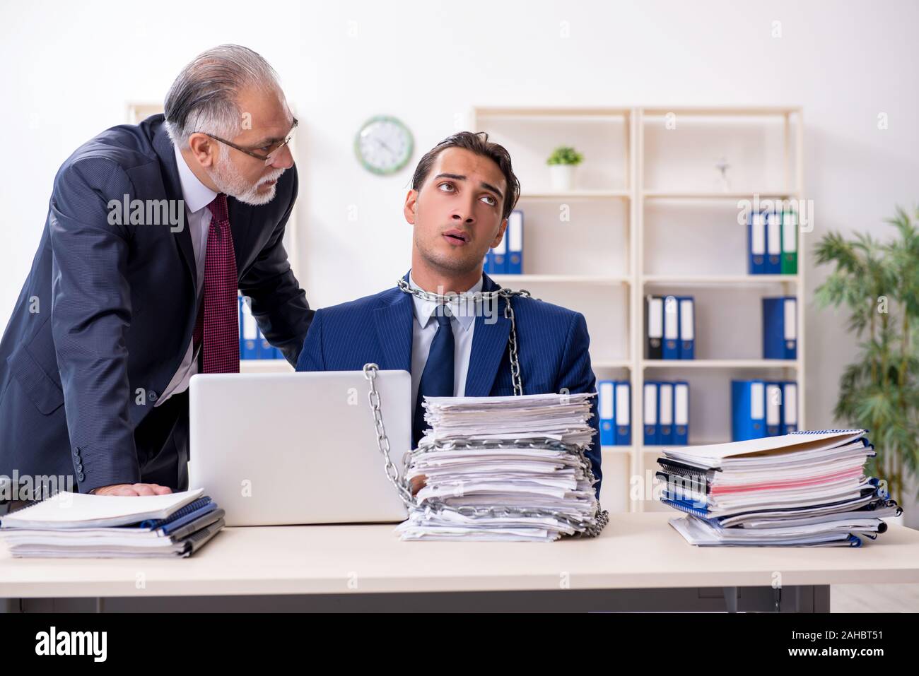 The old boss and young male employee in the office Stock Photo - Alamy