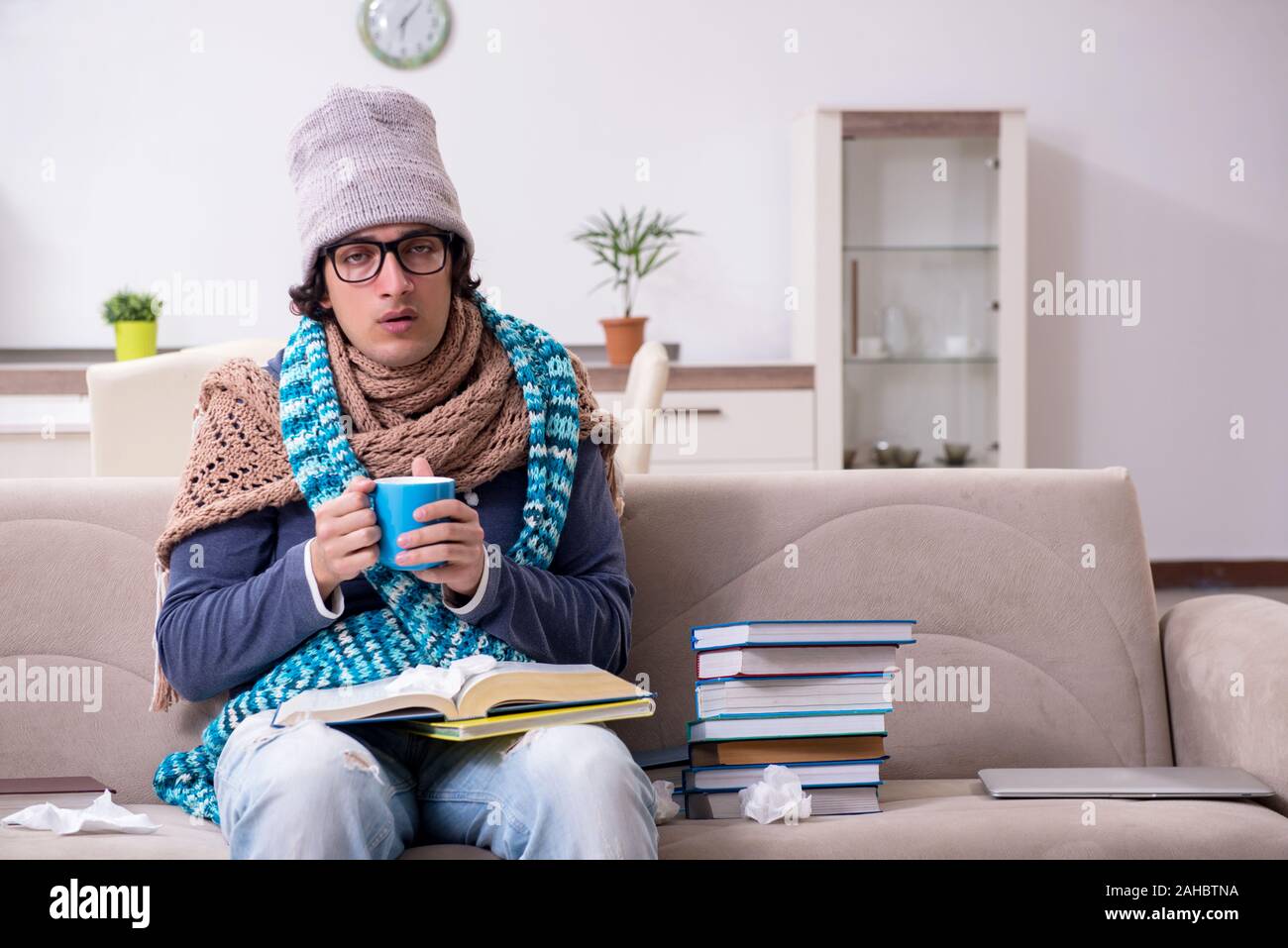 The sick male student suffering at home Stock Photo - Alamy
