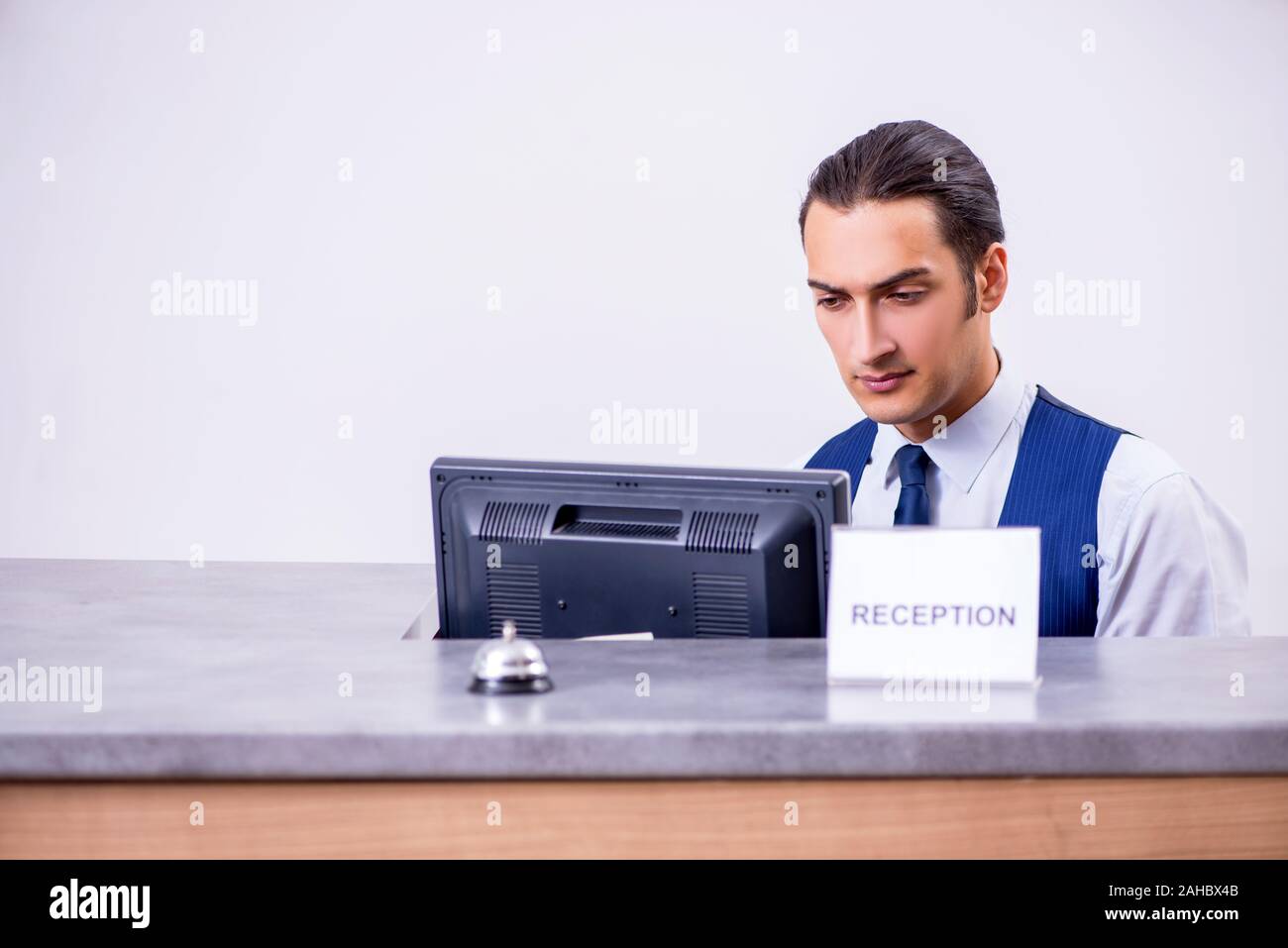 The young man receptionist at the hotel counter Stock Photo - Alamy