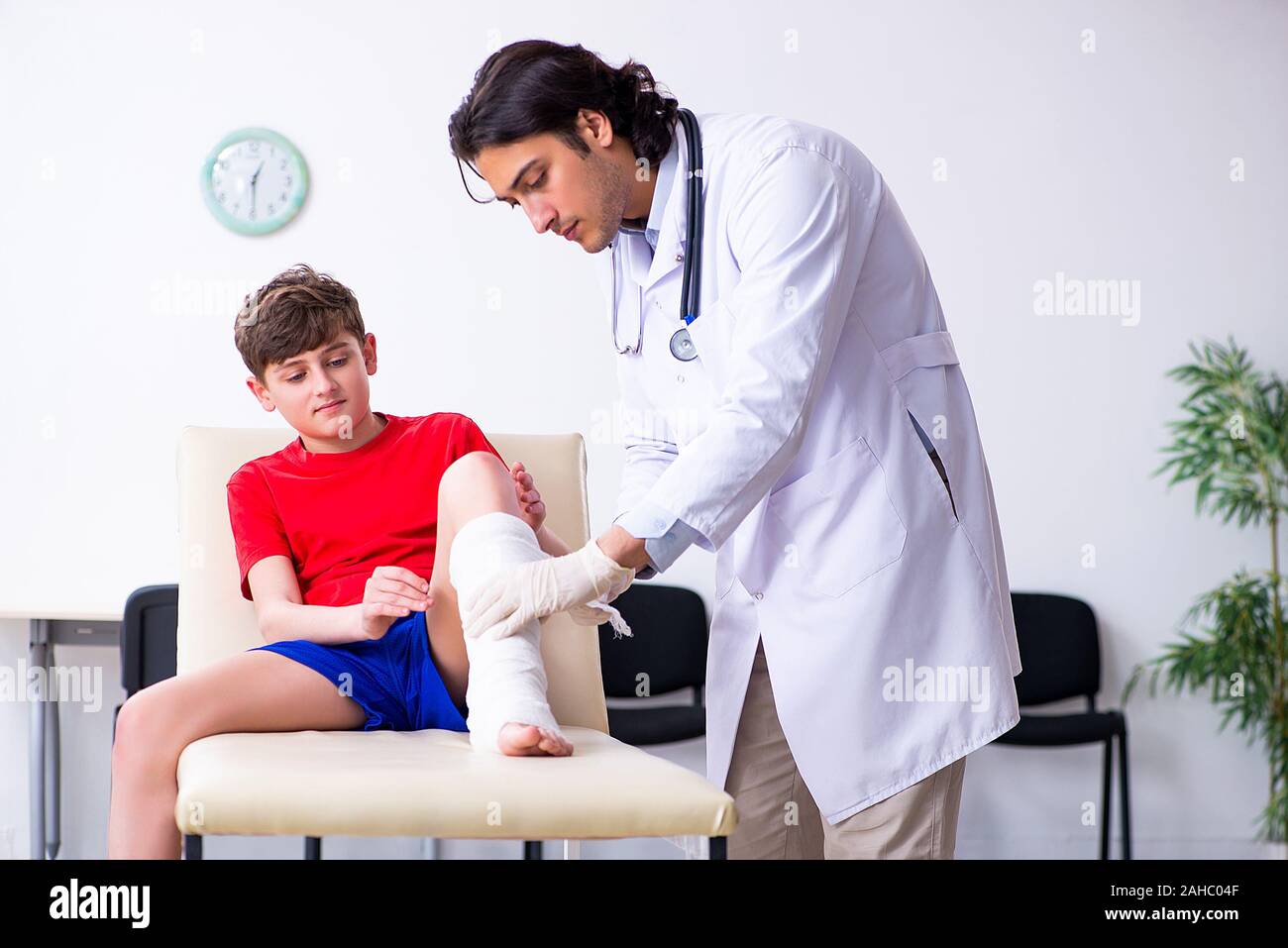 The leg injured boy visiting young doctor traumatologist Stock Photo ...