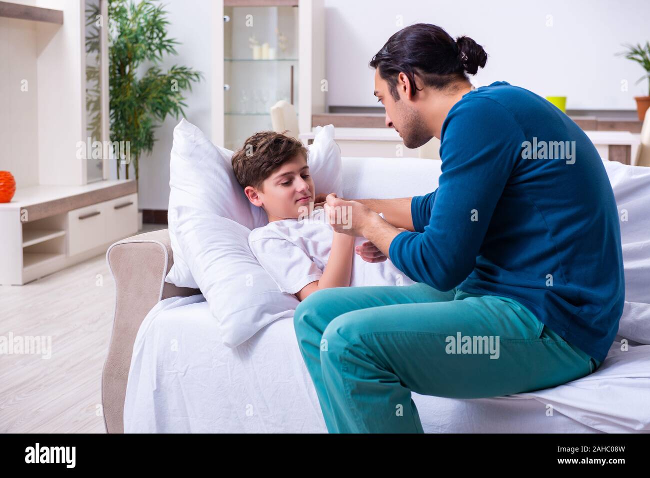 The young father caring for sick son Stock Photo - Alamy
