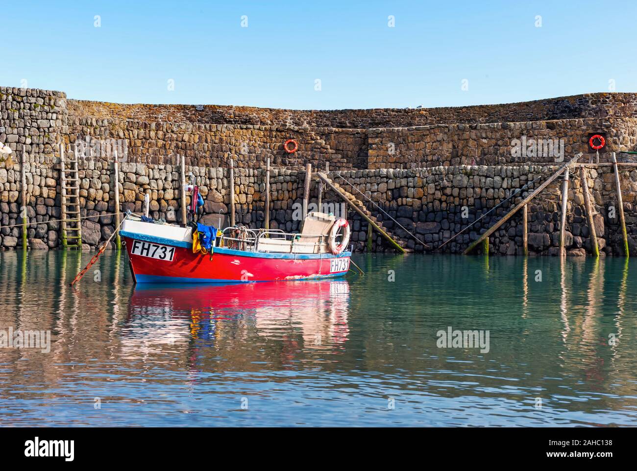 Red fishing boat moored at the harbour of Clovelly, this famous fishing ...