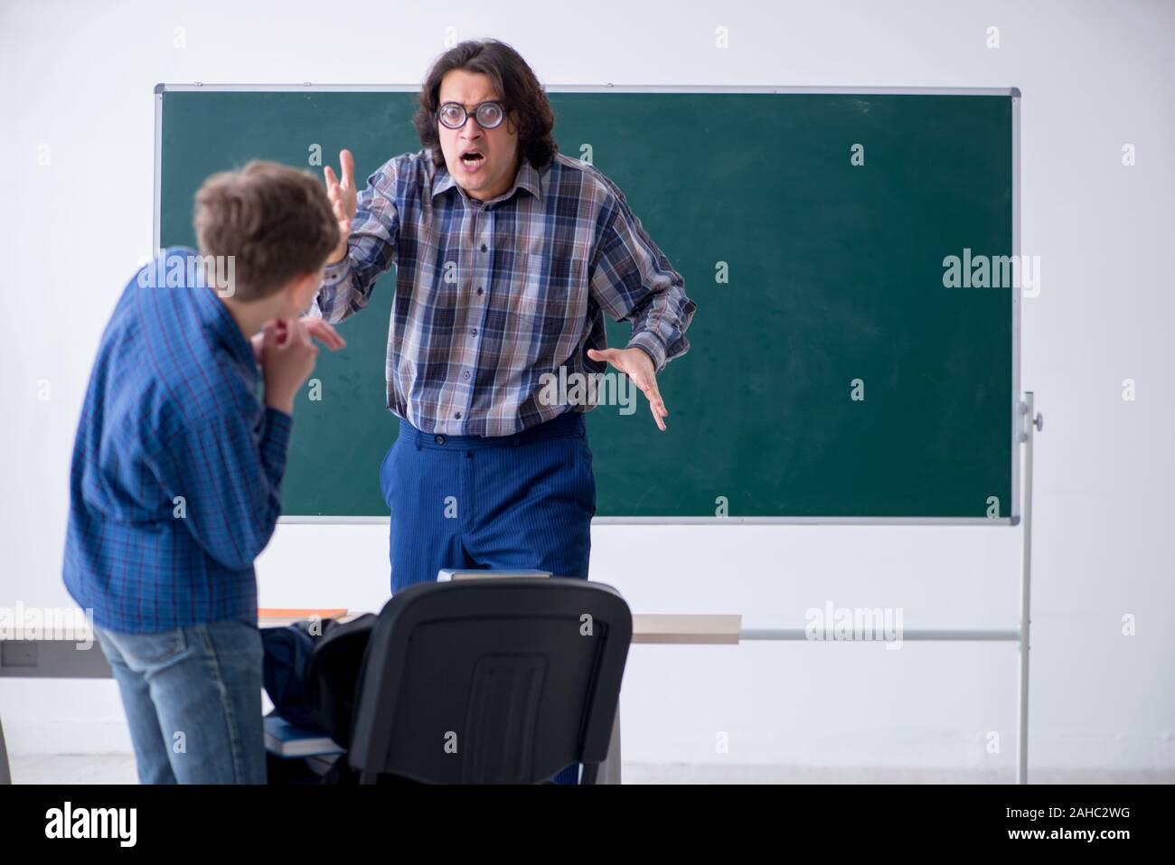 The funny male teacher and boy in the classroom Stock Photo - Alamy