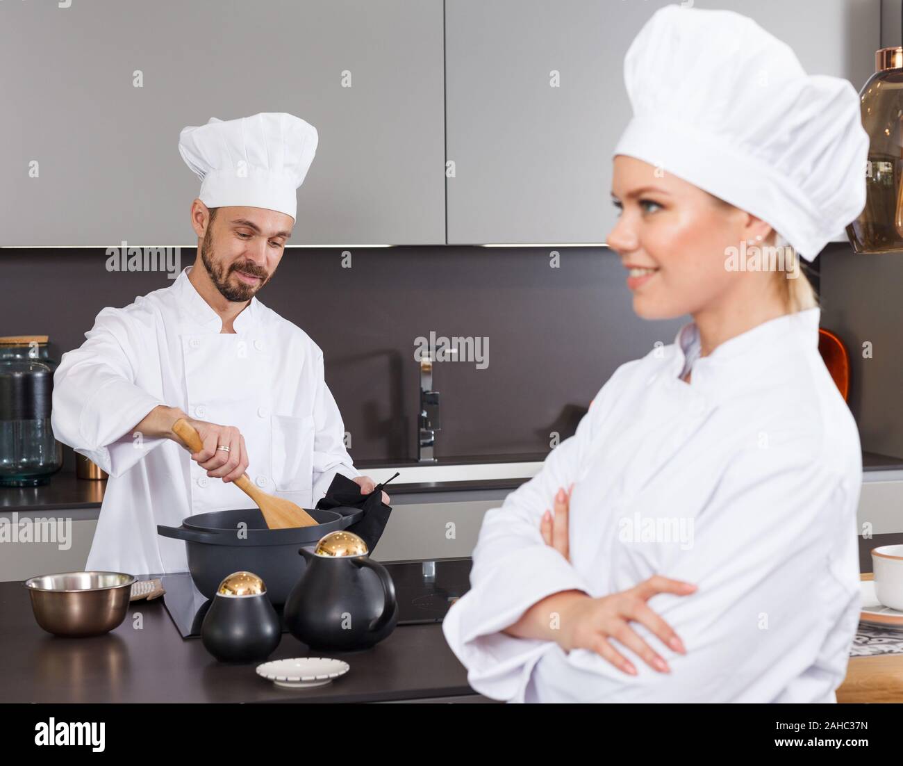 Confident personal male chef cooking in modern interior of private ...