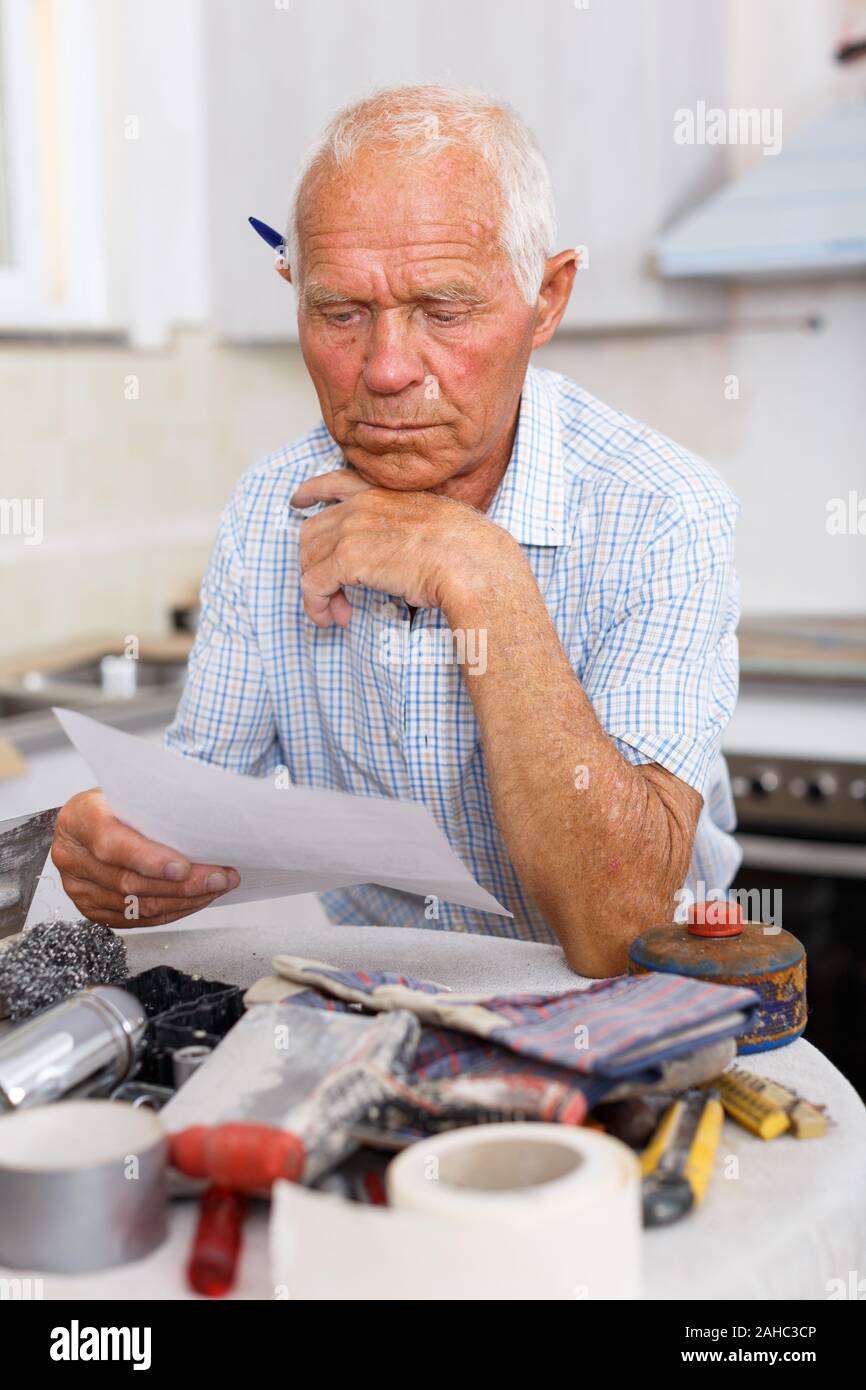 Thoughtful elderly man planning renovation works at his home, looking ...