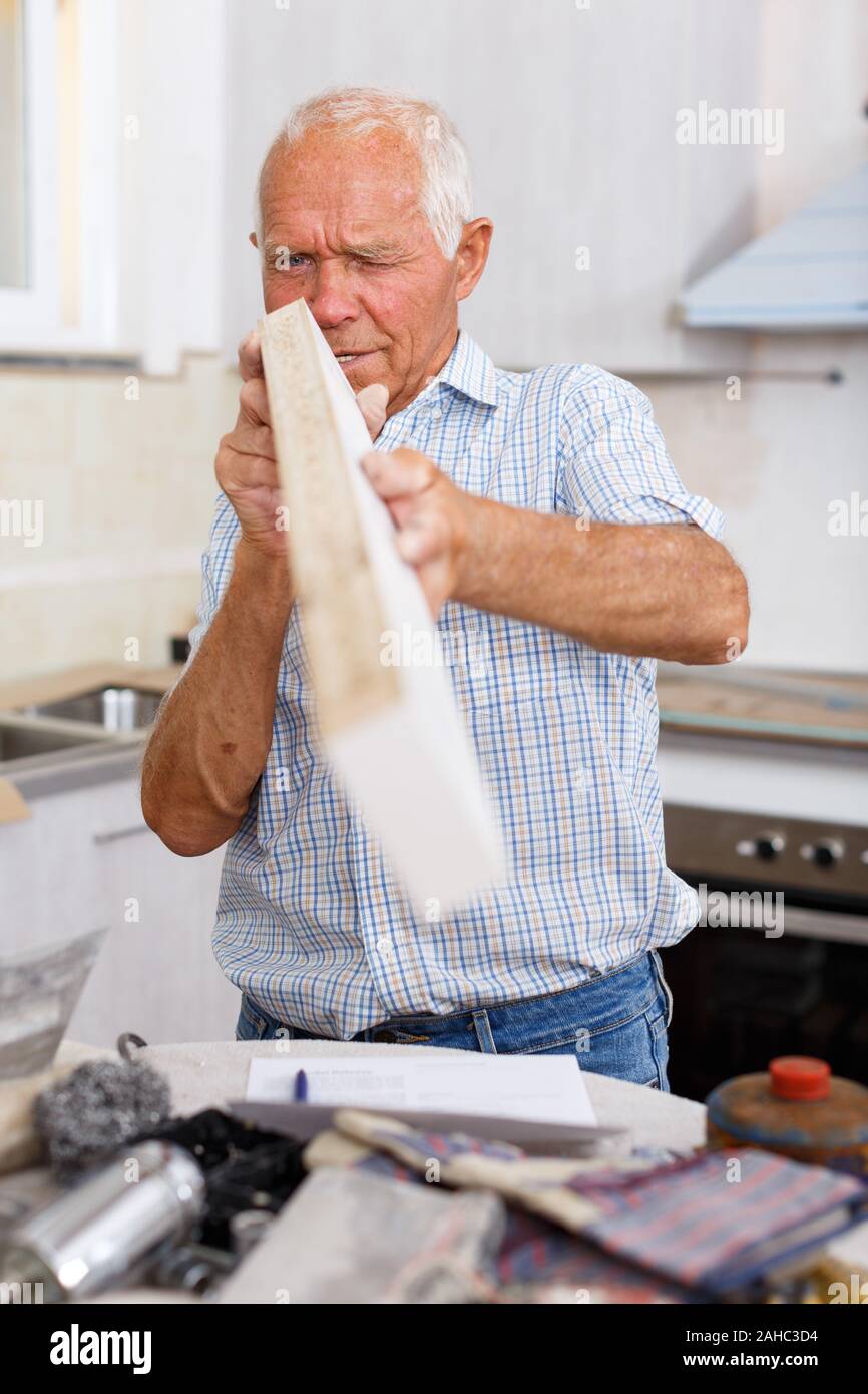 Skillful older man engaged on his home renovations, preparing wood ...