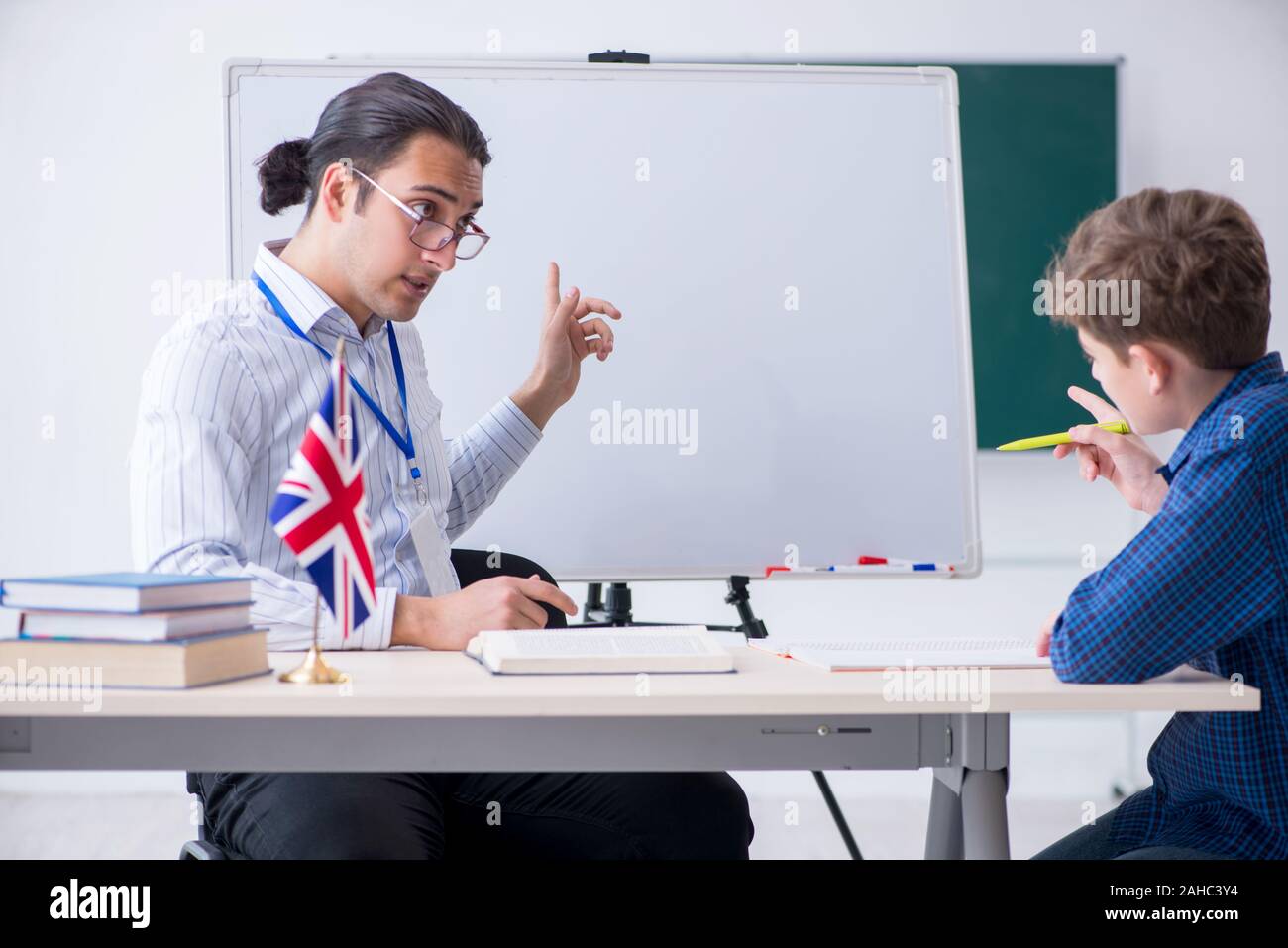 The male english teacher and boy in the classroom Stock Photo - Alamy