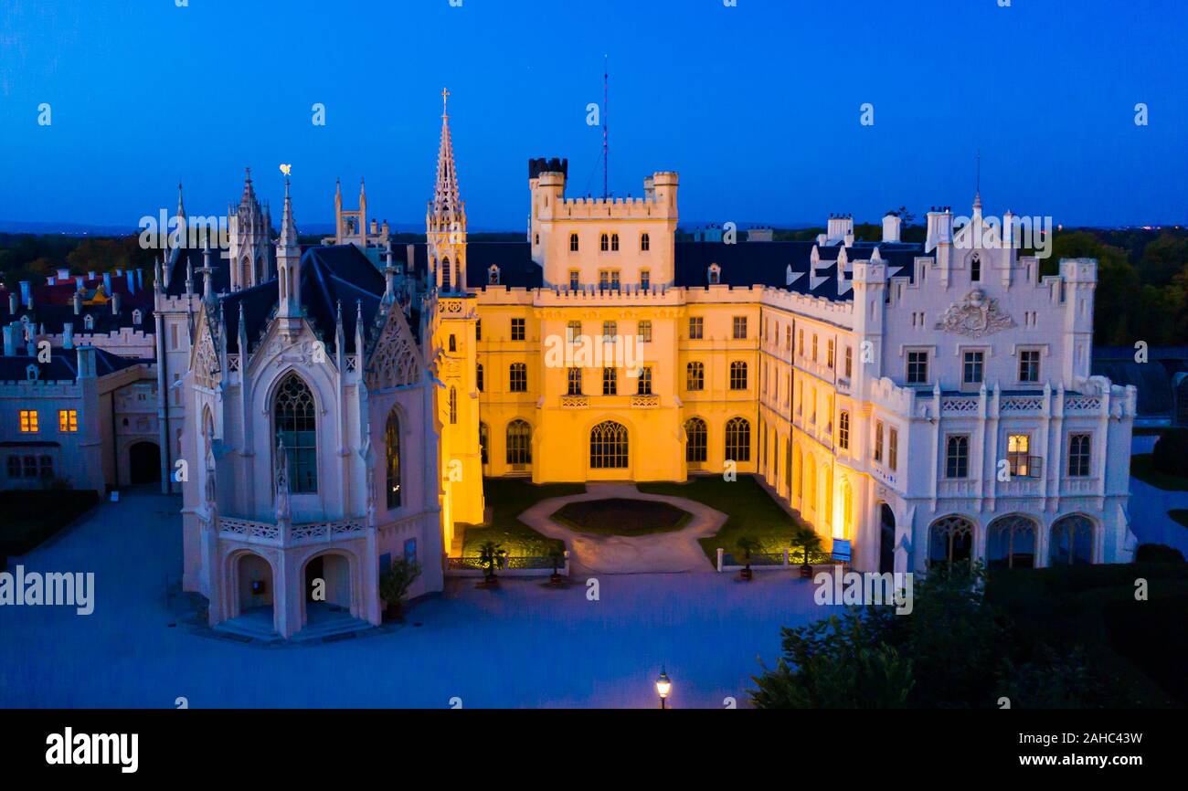 Aerial view of illuminated Palace complex of Lednice with large chateau ...