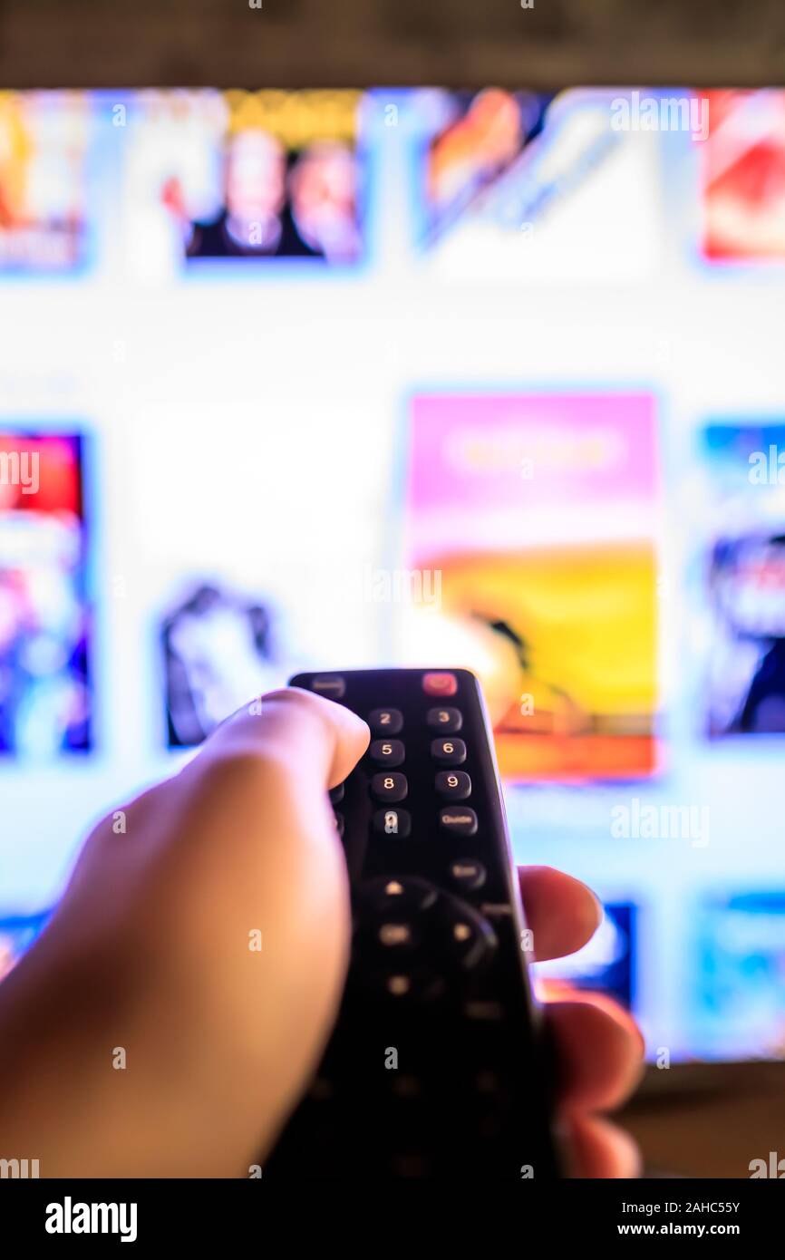 Video on demand screen with remote control in hand, streaming Stock ...