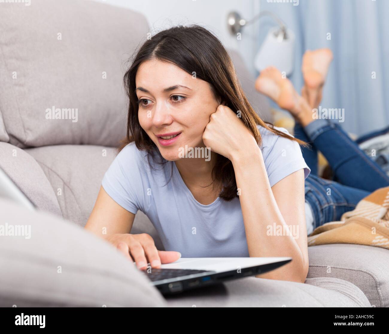 Young woman student resting with laptop on sofa at home interior Stock ...