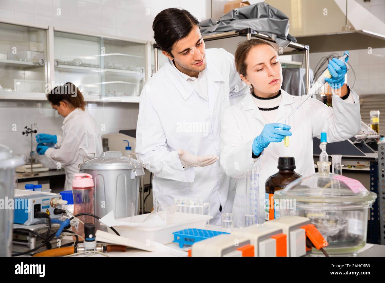 Two diligent positive students performing experiments in university ...