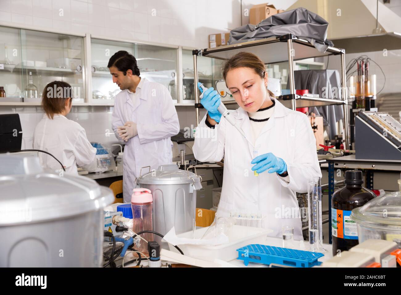 Female student performing experiments in university laboratory, using ...