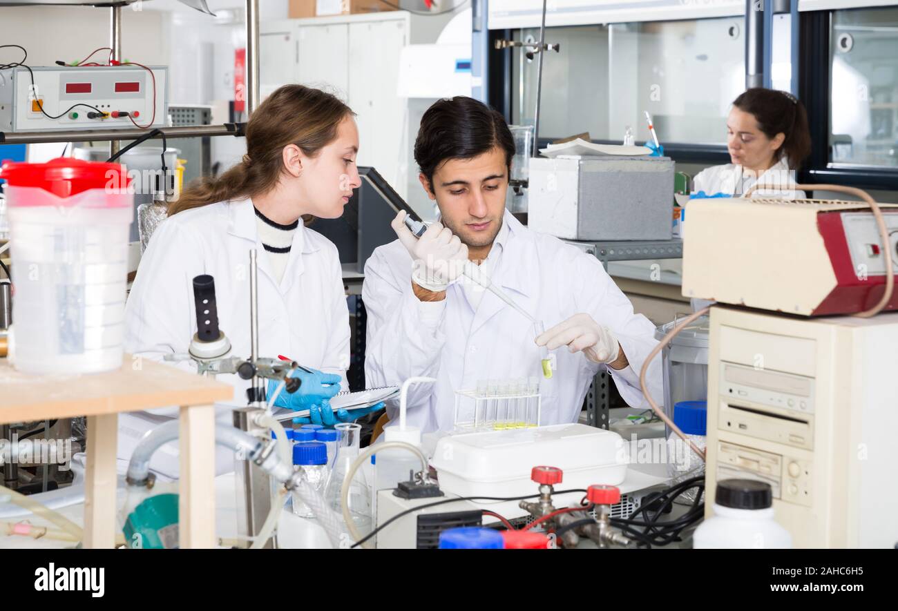 Two nice lab technicians discussing while working with reagents in test ...
