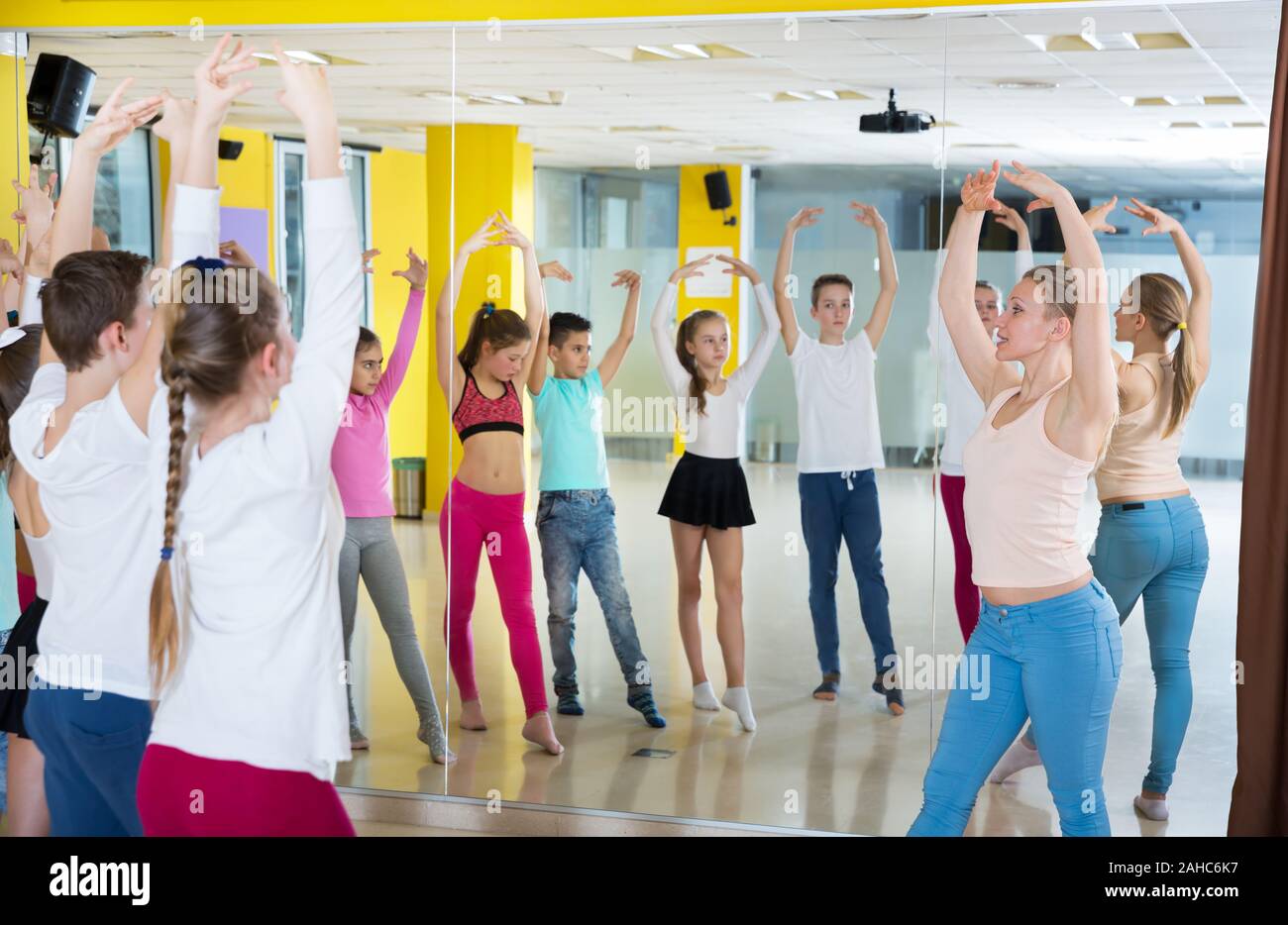 Female coach holding group dance training with their teenagers in ...