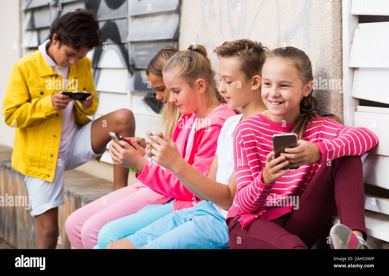 Children are playing on smartphone in the playground Stock Photo - Alamy