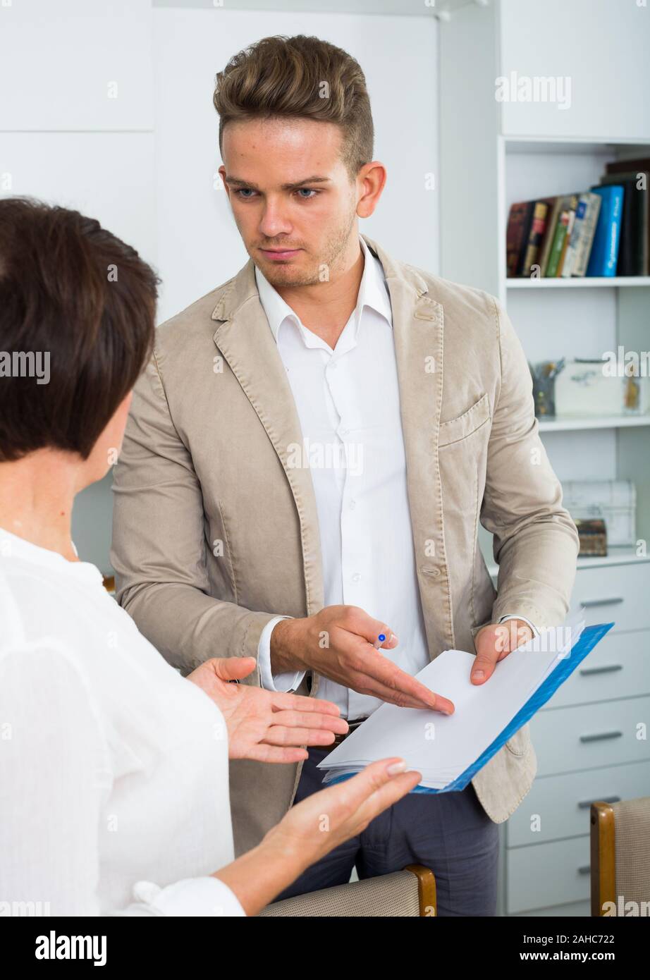 Woman refuses to sign documents which to her are shown by young man ...