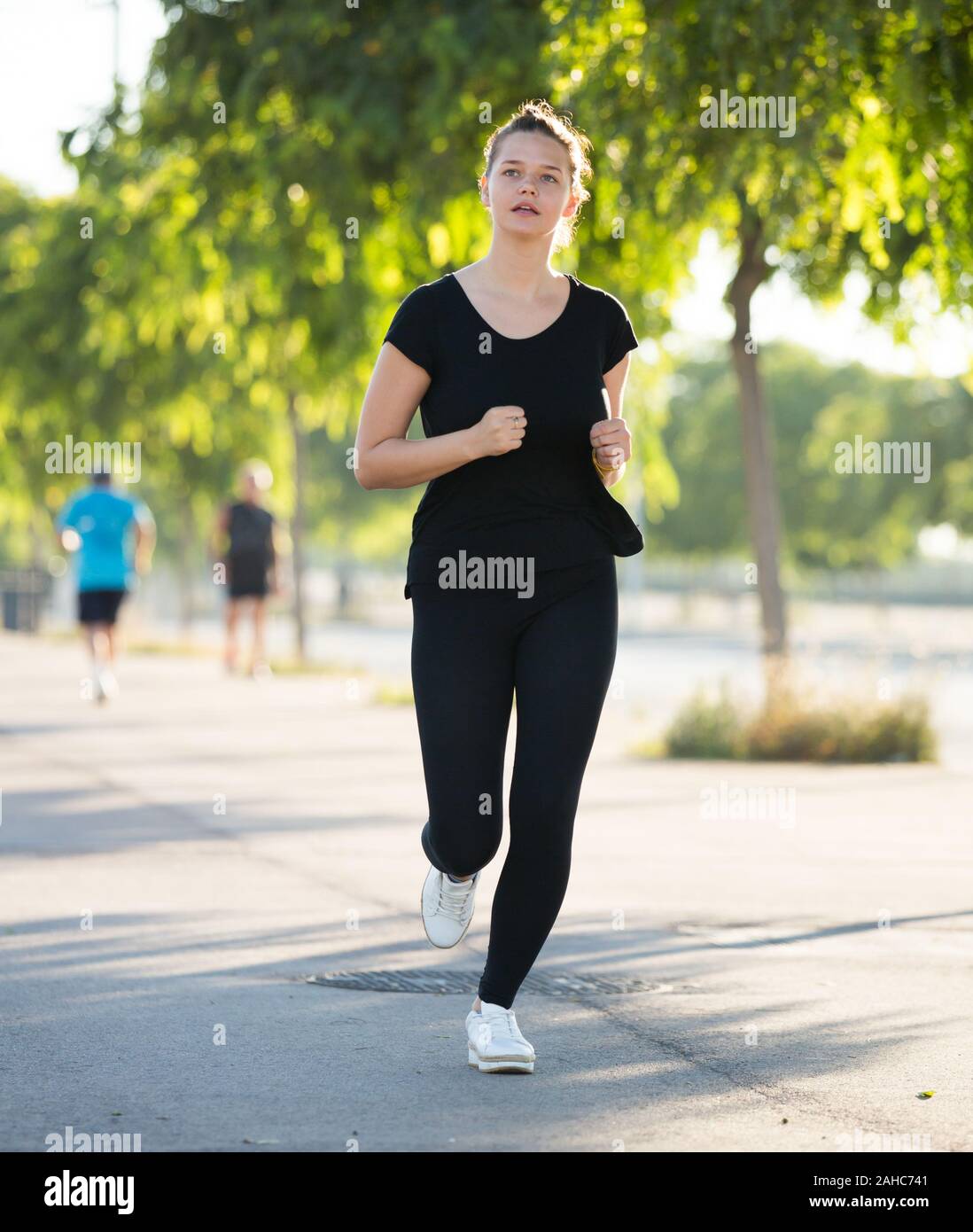 Sporty svelte girl jogging during outdoor daily workout Stock Photo - Alamy